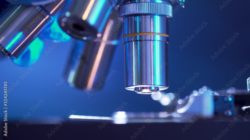 The objective lenses of the turret of a microscope being positioned by ...