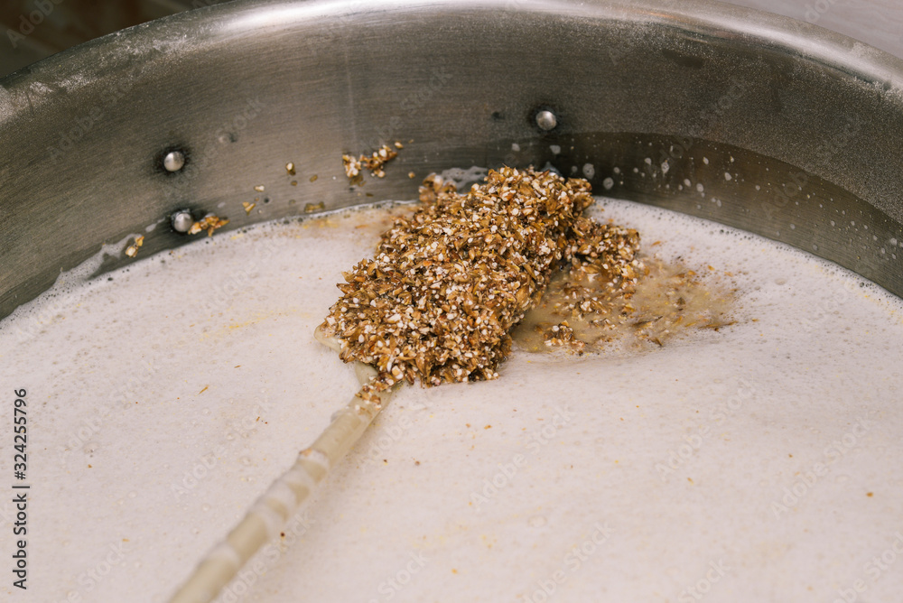 Ground malt in a water tank. Ingredients for brewing close-up. Beer ...