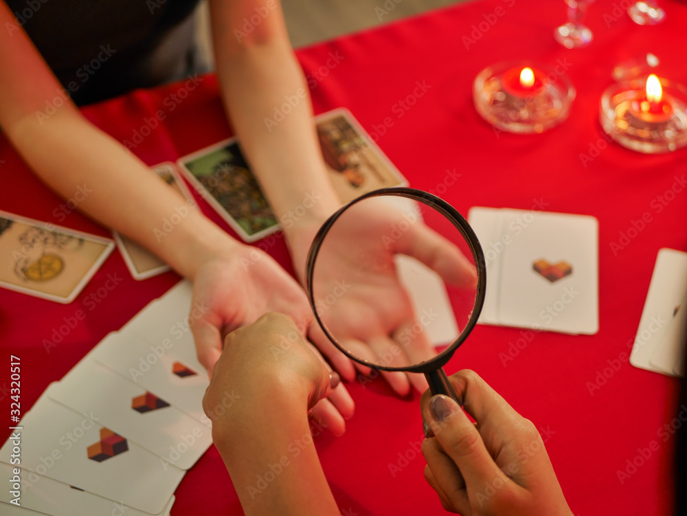the hands of asian young woman at the table of fortune teller using the ...