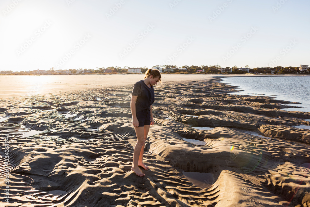 A teenage girl playing in sand dunes, at the beach,St Simon's Island ...