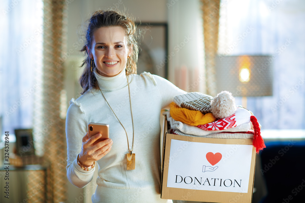 happy stylish woman with donation box with clothes using app Stock ...
