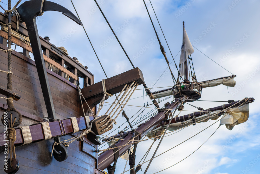 Anchor, masts and rigging of old pirate ship on background of cloudy ...