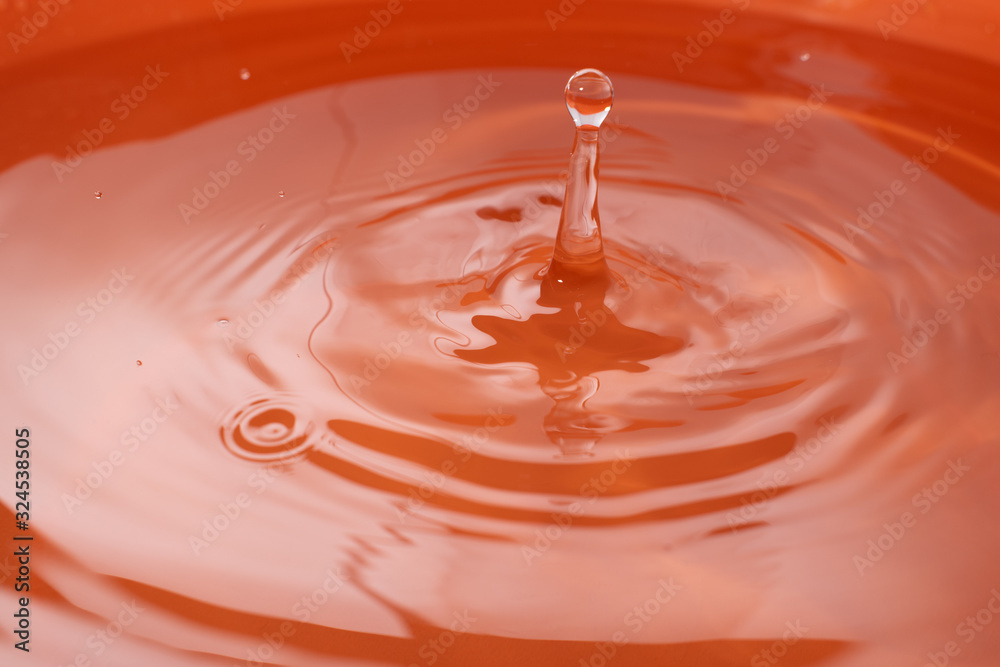 Water drop falling and drips in colored glass. Water drop splash and ...