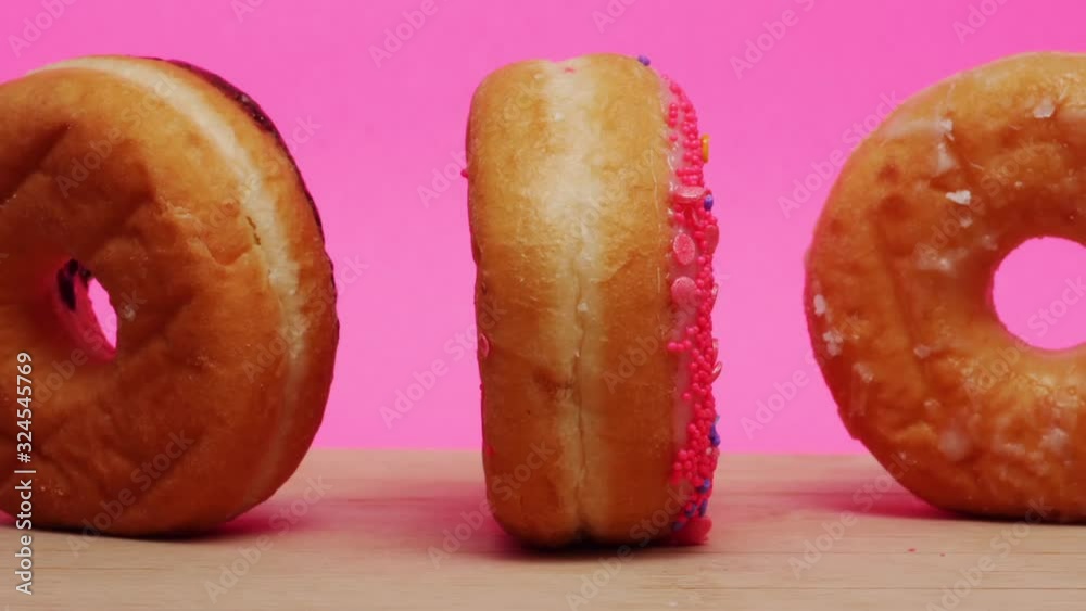3 Donuts spinning around on a table. Stop motion animation with a ...