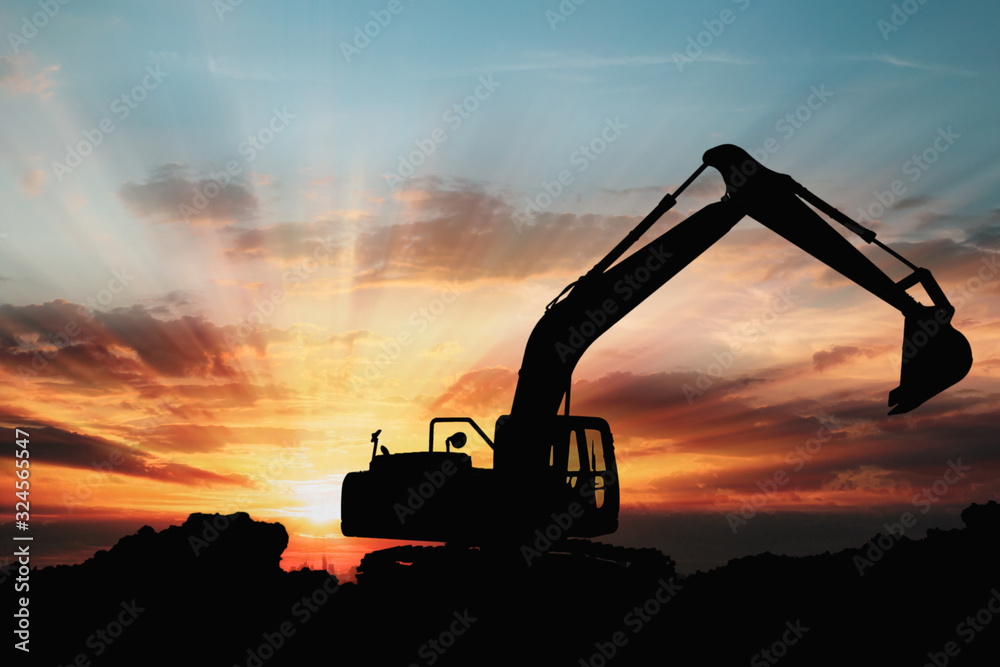 Excavators are digging the soil in the construction site on the sunset ...