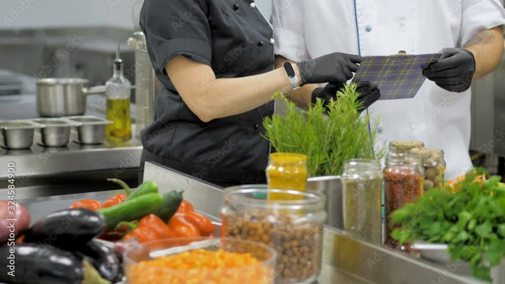 Restaurant chef makes a verification in kitchen. Interacting to head ...