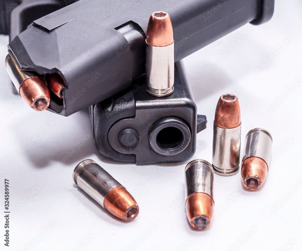 A black 9mm pistol with a pistol magazine loaded with 9mm hollow point ...
