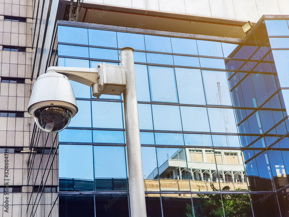 Security surveillance camera in front of office building walk way ...