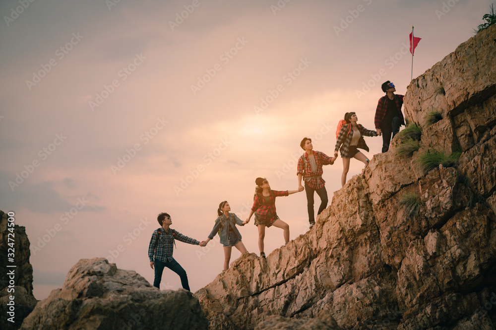 Team of climbers man and woman hiker holding hands to help each other ...