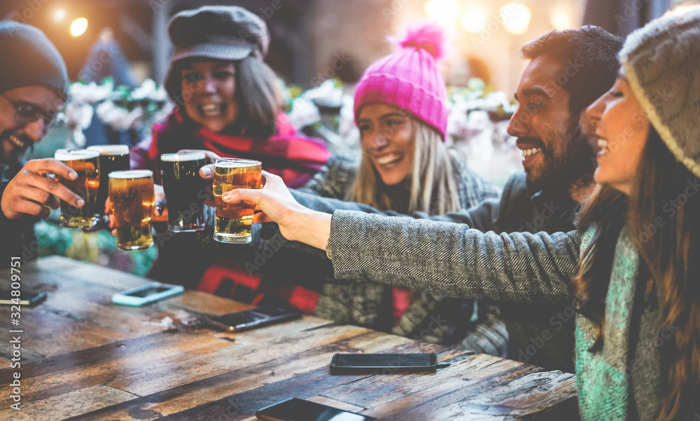 Group of happy friends drinking and toasting beer at brewery bar ...