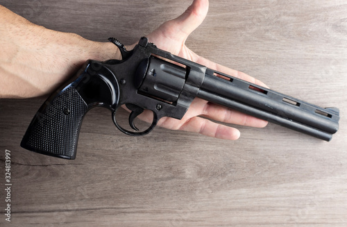 Mano de hombres con pistola revólver aislado sobre un fondo de madera ...