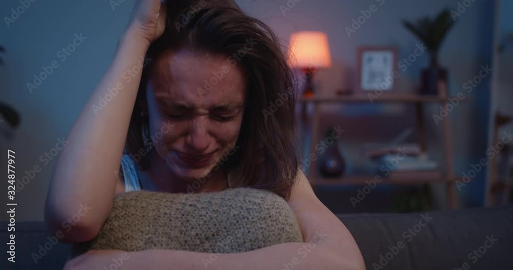 Close up of unhappy woman sitting in fetal position and weeping ...