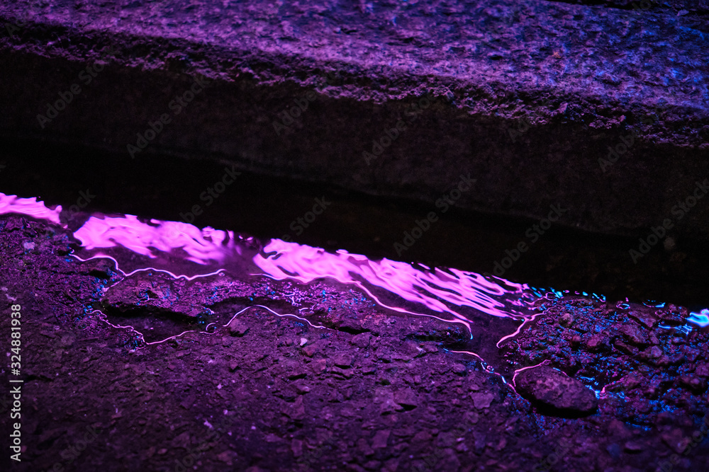 Purple neon reflection in a water puddle. Hong Kong street at night ...