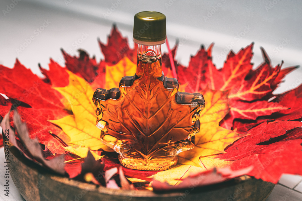Maple syrup bottle in red maple tree leaves for tourist gift souvenir ...