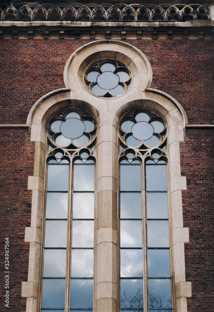 Round window with stained glass on facade of the building. Baroque and ...