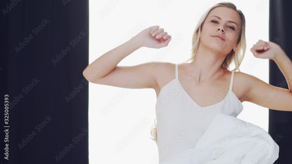 Young woman in the bed. Beautiful blond girl wakes up. Morning in the ...