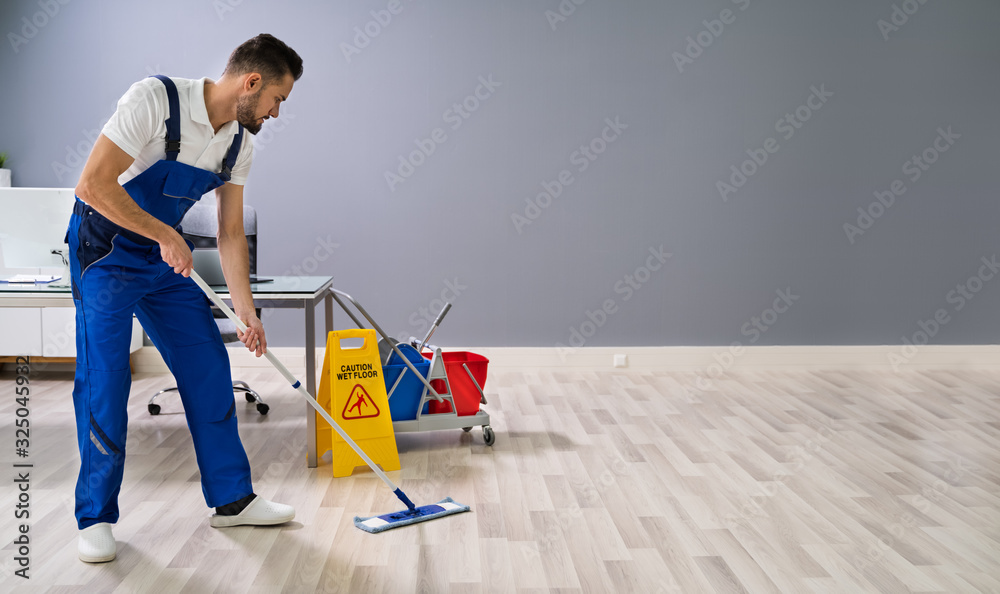 Worker Mopping Floor With Wet Floor Caution Sign Stock Photo | Adobe Stock