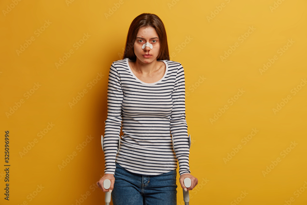 Serious woman with bruised bleeding face, being accident victim, wears ...