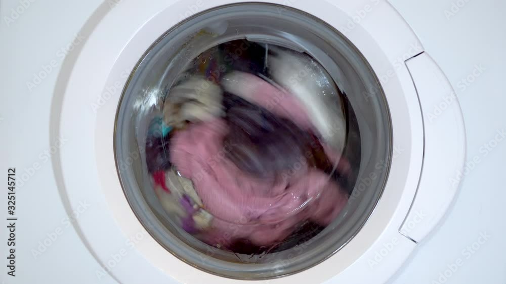 Washing machine working with laundry. Washing machine washes colored ...