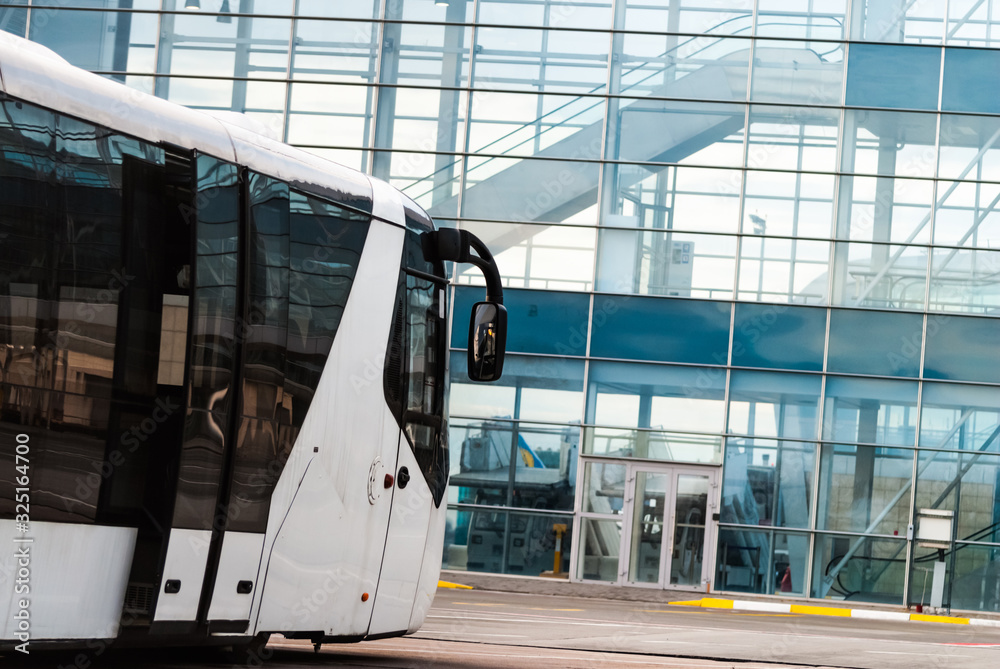 White modern tour bus and glass building. Shuttle bus in the airport ...