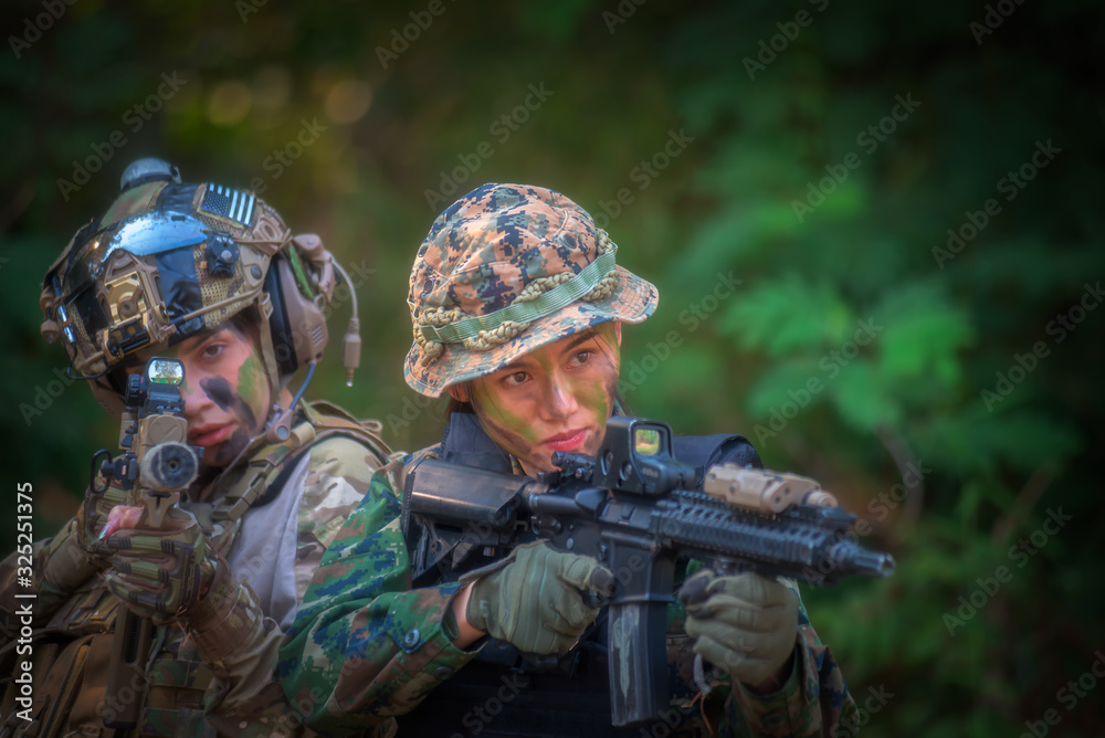 Two female soldiers are ready for fighting with guns. War, soldier army ...