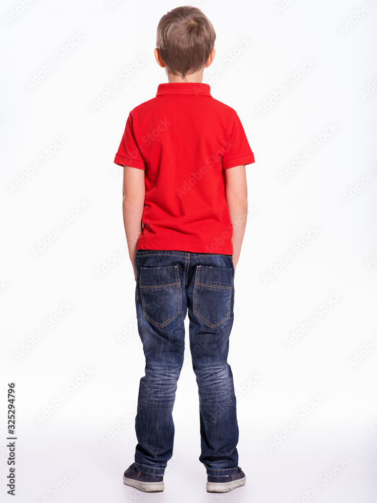Full length portrait of a child standing back to the camera. Kid stands ...