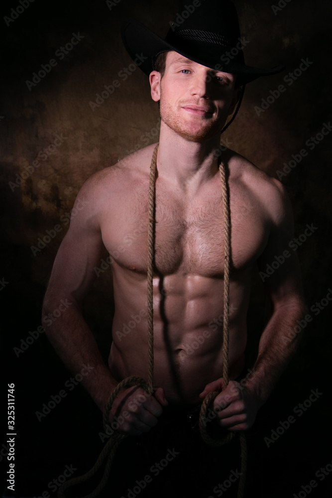 Handsome cowboy wearing a hat with barechest showing defined pecs and ...
