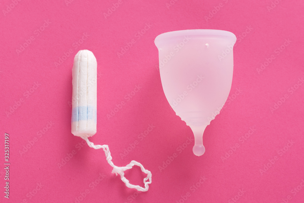 Studio shot of sanitary cotton tampon and menstrual cup isolated over ...