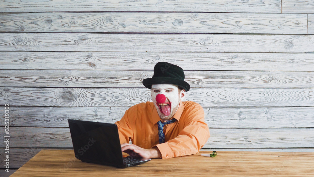 Office worker clown, clown concept at work. Businessman at the computer ...