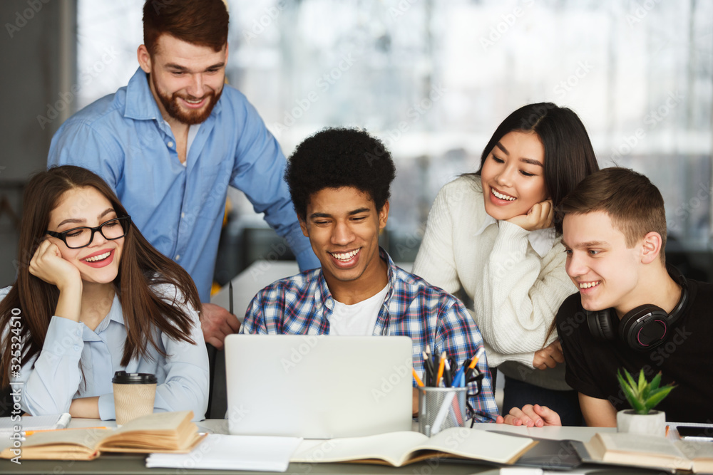 Happy students watching tutorial videos on laptop Stock Photo | Adobe Stock