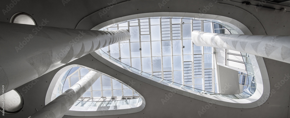 Super wide angle of a white atrium with skylight taken from below with ...