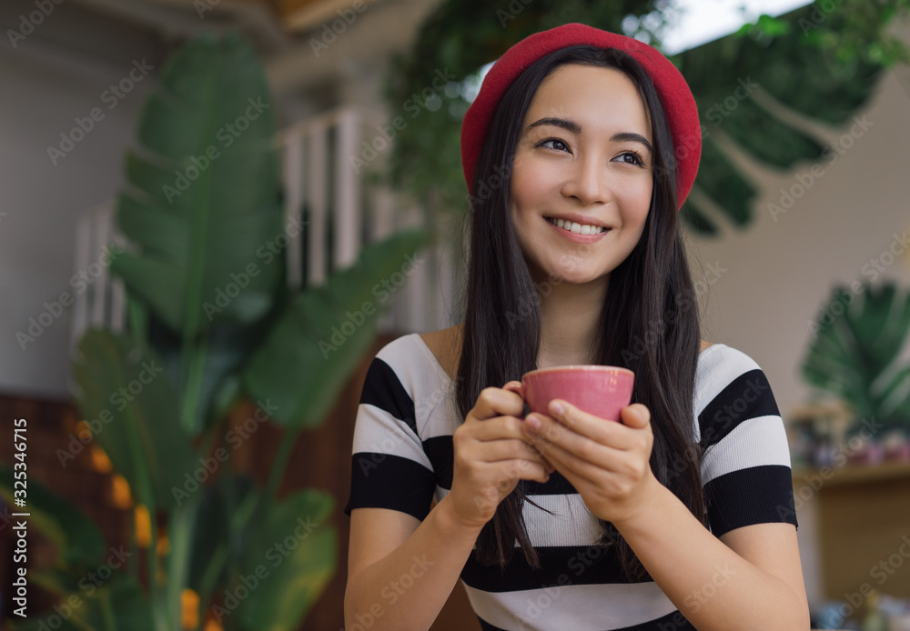 Young Asian woman drinking coffee in cafe. Portrait of positive hipster ...