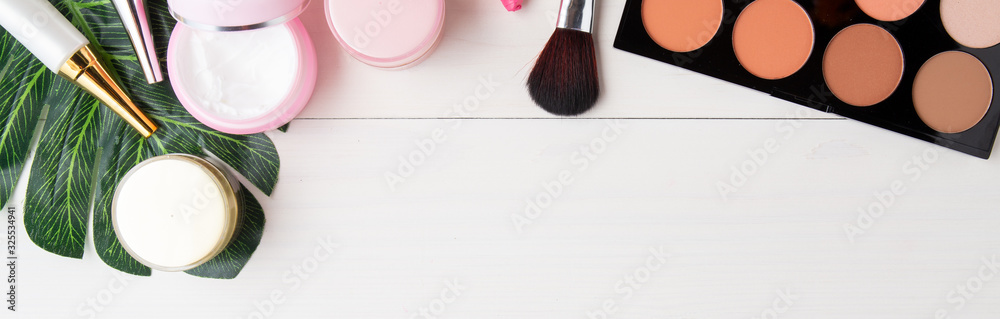 cosmetic makeup and skin care product and leaves on white wood table ...