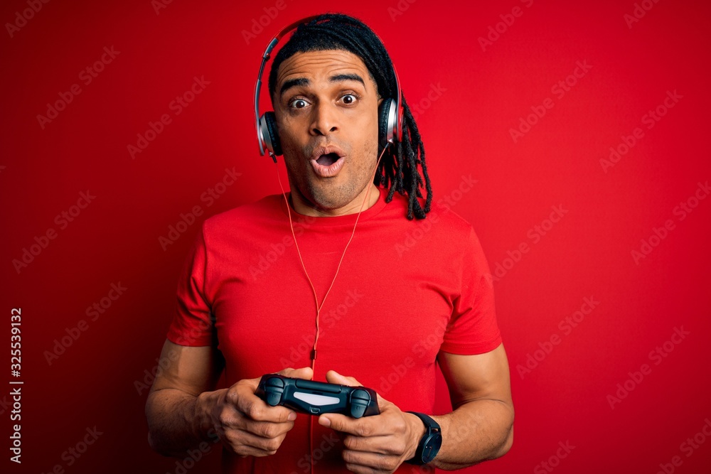 African american man with dreadlocks playing video game using joystick ...