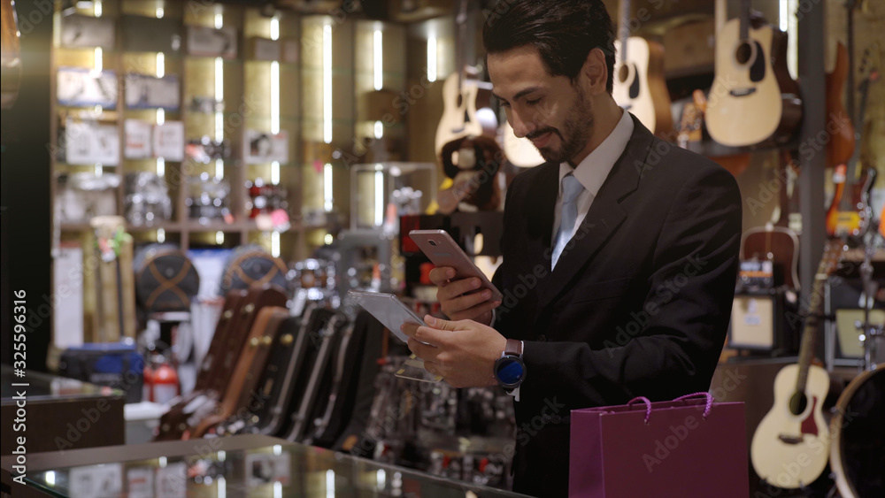 An upwardly mobile Middle Eastern man using a mobile phone - smartwatch ...