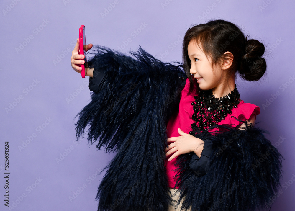 Cute smiling asian korean girl kid using new popular red gadget mobile ...