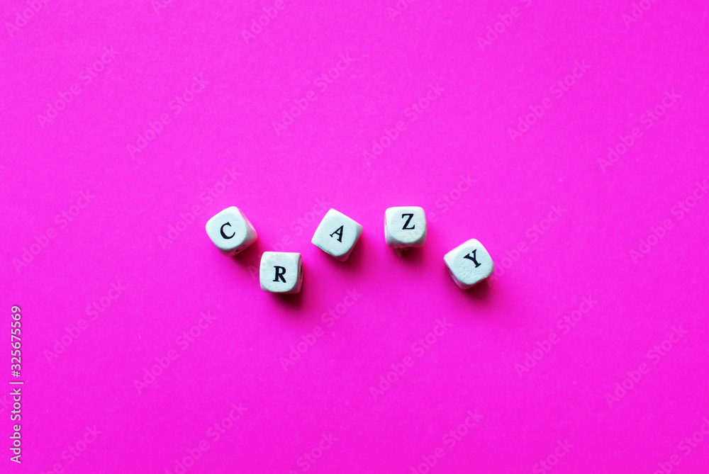 Crazy wooden cube letters with bright pink background. Crazy world ...