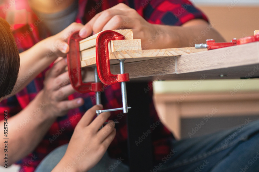 Foto de Close up little boy hand and father using a C clamp in his ...
