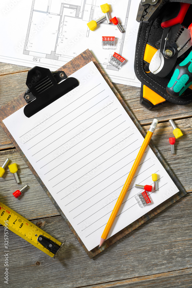 Open Notepad and tools of an electrician installer or Builder on a gray ...
