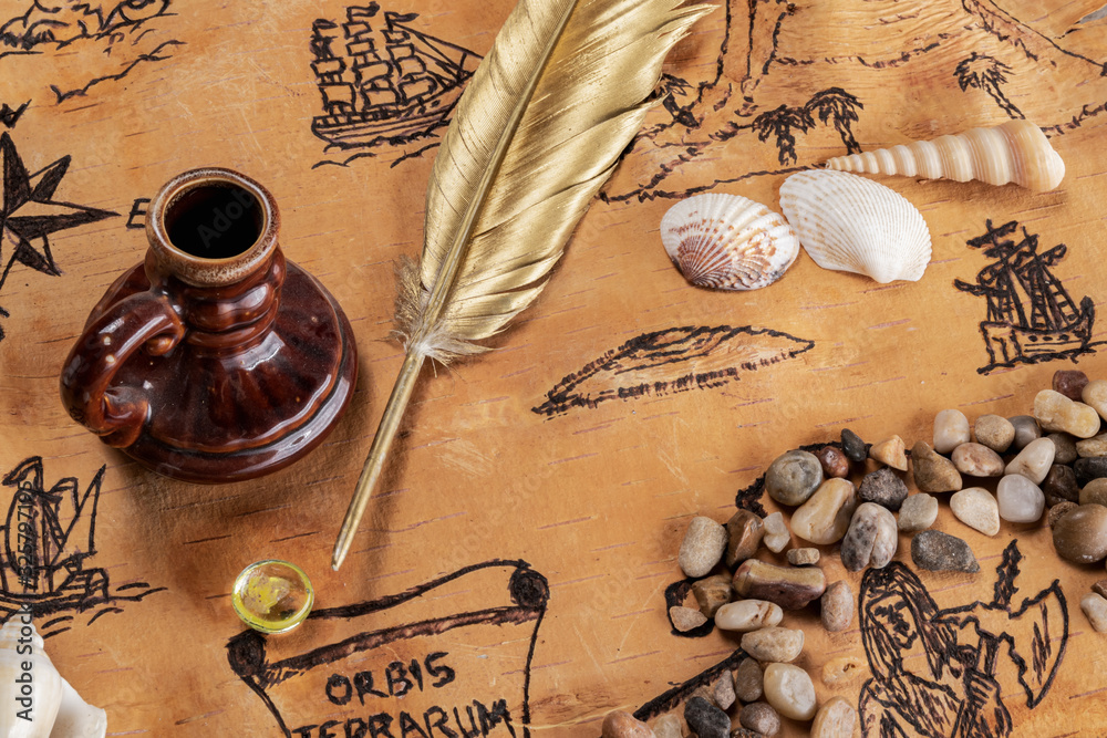 Gold quill pen on sea map with illustrations of sailing vessels and ...