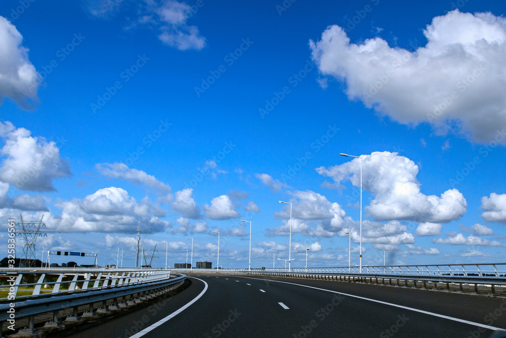 Image of Empty Freeway under a bright blue sky. Long asphalt road with ...