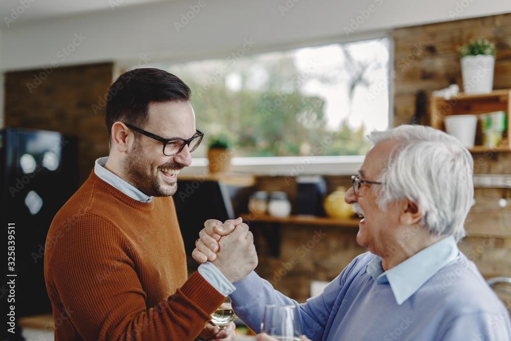 Happy man and his senior father giving each other manly greet in the ...