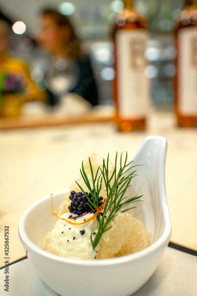 Amuse Bouche appetizer. Black caviar and cheese based cream on ...