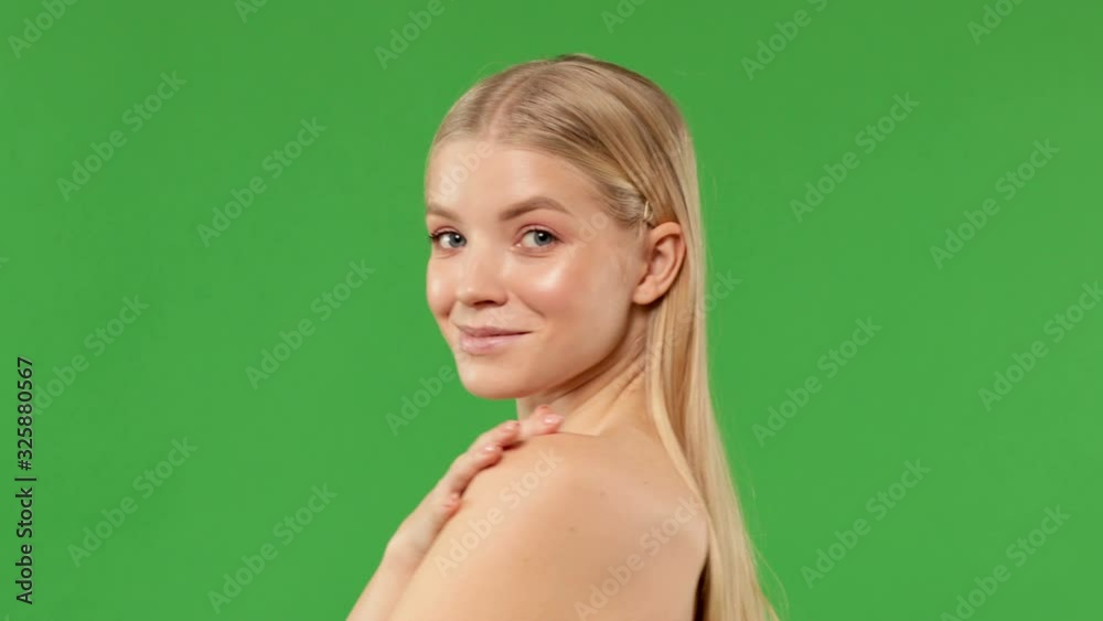 Stockvideon Young pretty girl with bare shoulders mysteriously smiles ...