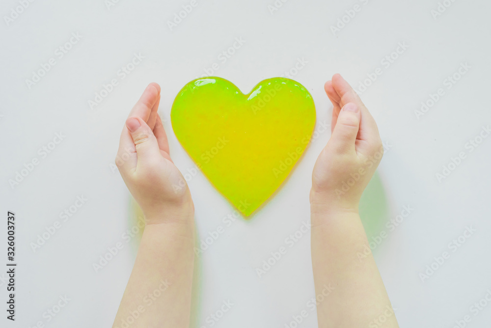 Slime heart in the hands. Sticky mucus in the hand. The child wrinkles ...