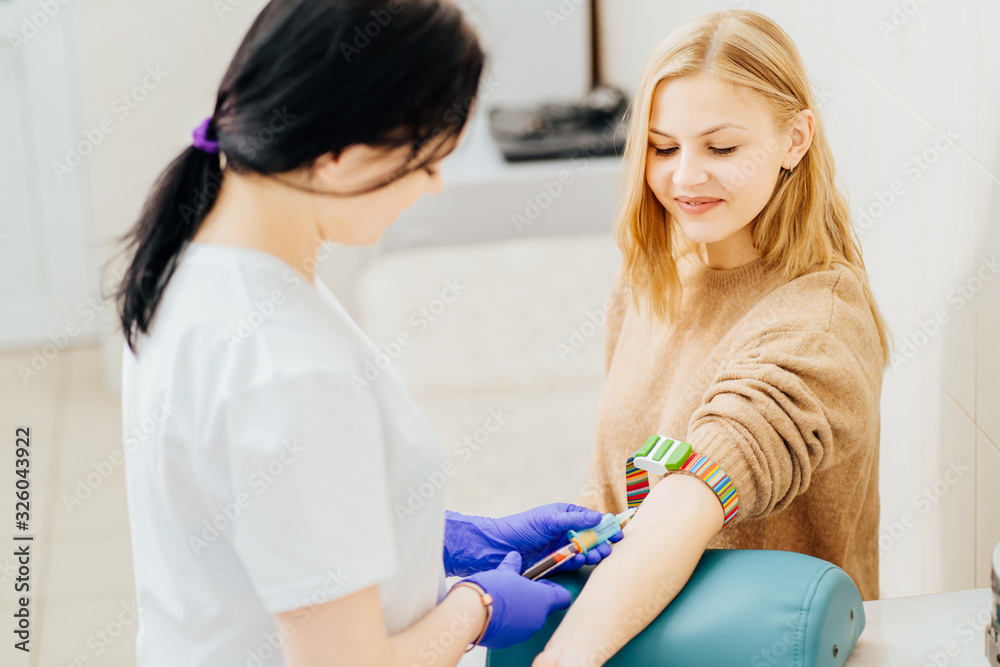 Female nurse making mature woman blood sampling to test her health ...