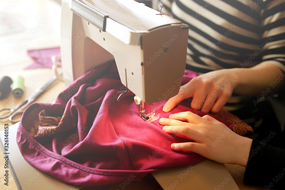 young girl learns from her mother to repair her clothes with a vintage ...