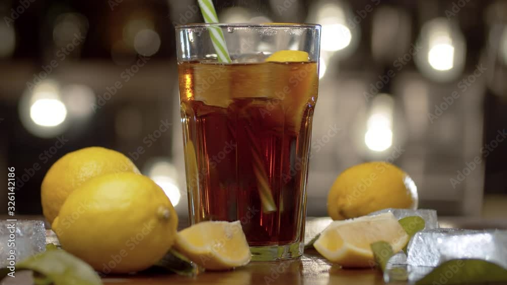 Close up long island ice tea stirring into the glass with drinking ...