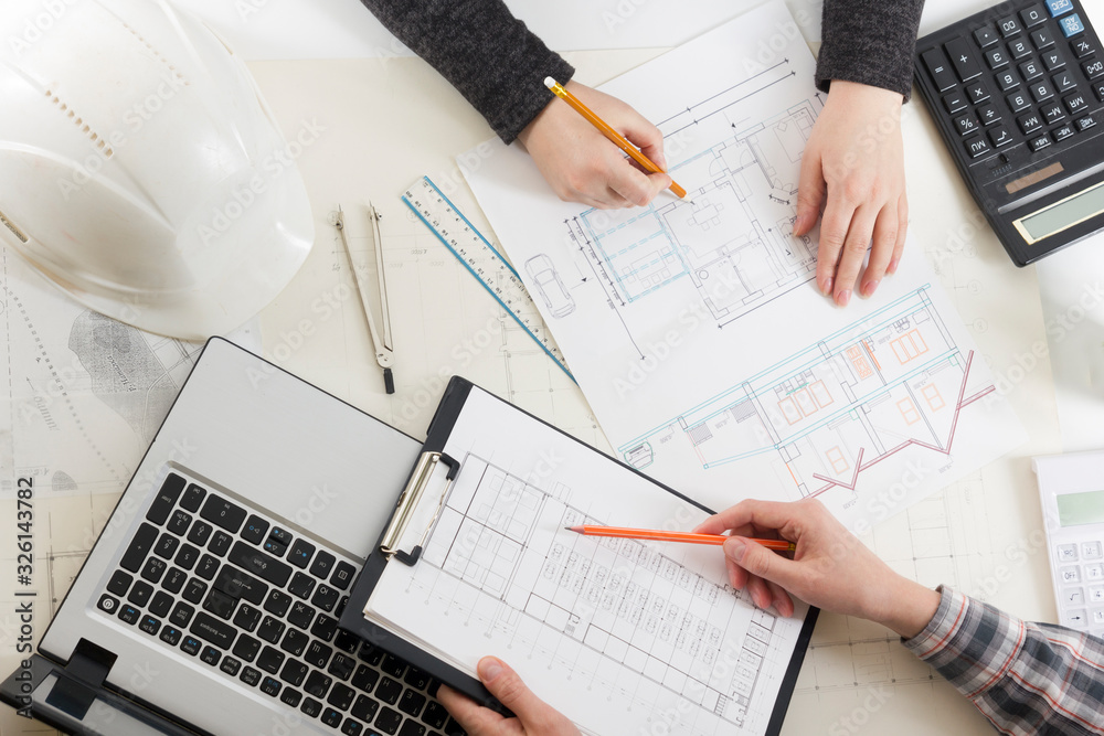 Architects working on blueprint, real estate project. Architect ...