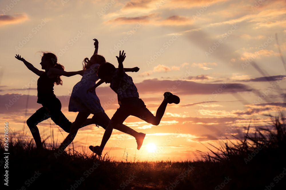 Happy children playing in the park at the sunset time. Stock Photo ...